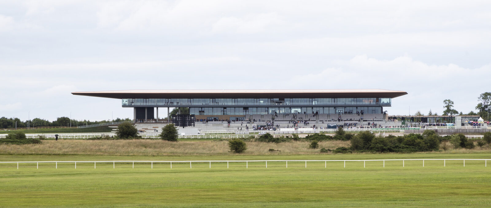 Floating copper roof marks out Grimshaw’s racecourse grandstand