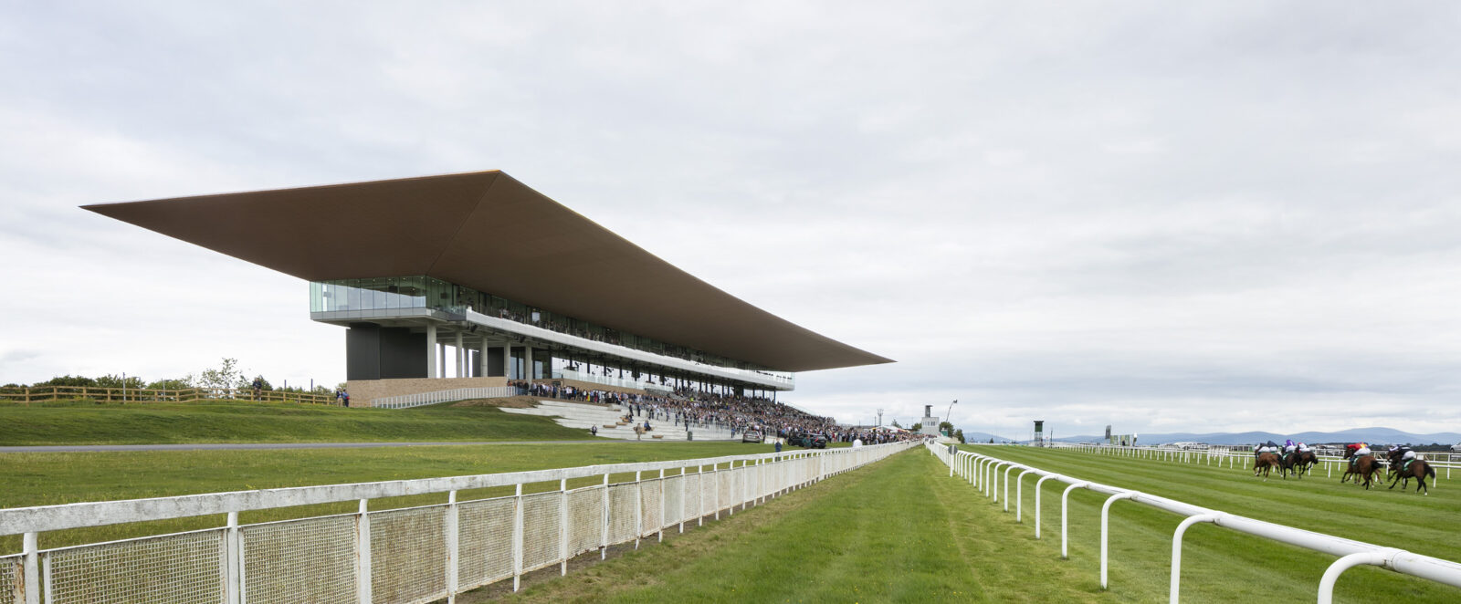 Floating copper roof marks out Grimshaw’s racecourse grandstand
